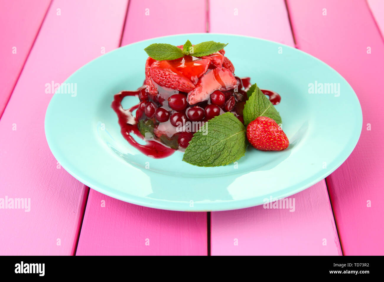Tasty jelly dessert with fresh berries, on color wooden background ...