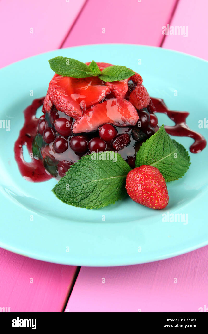 Tasty jelly dessert with fresh berries, on color wooden background ...