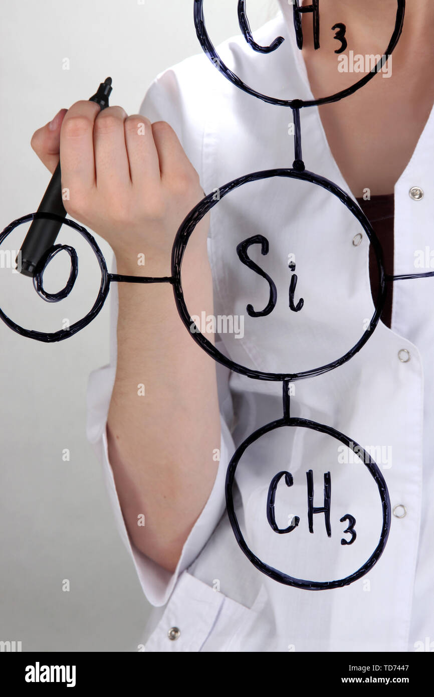 Chemist woman writing formulas on glass on grey background Stock Photo ...