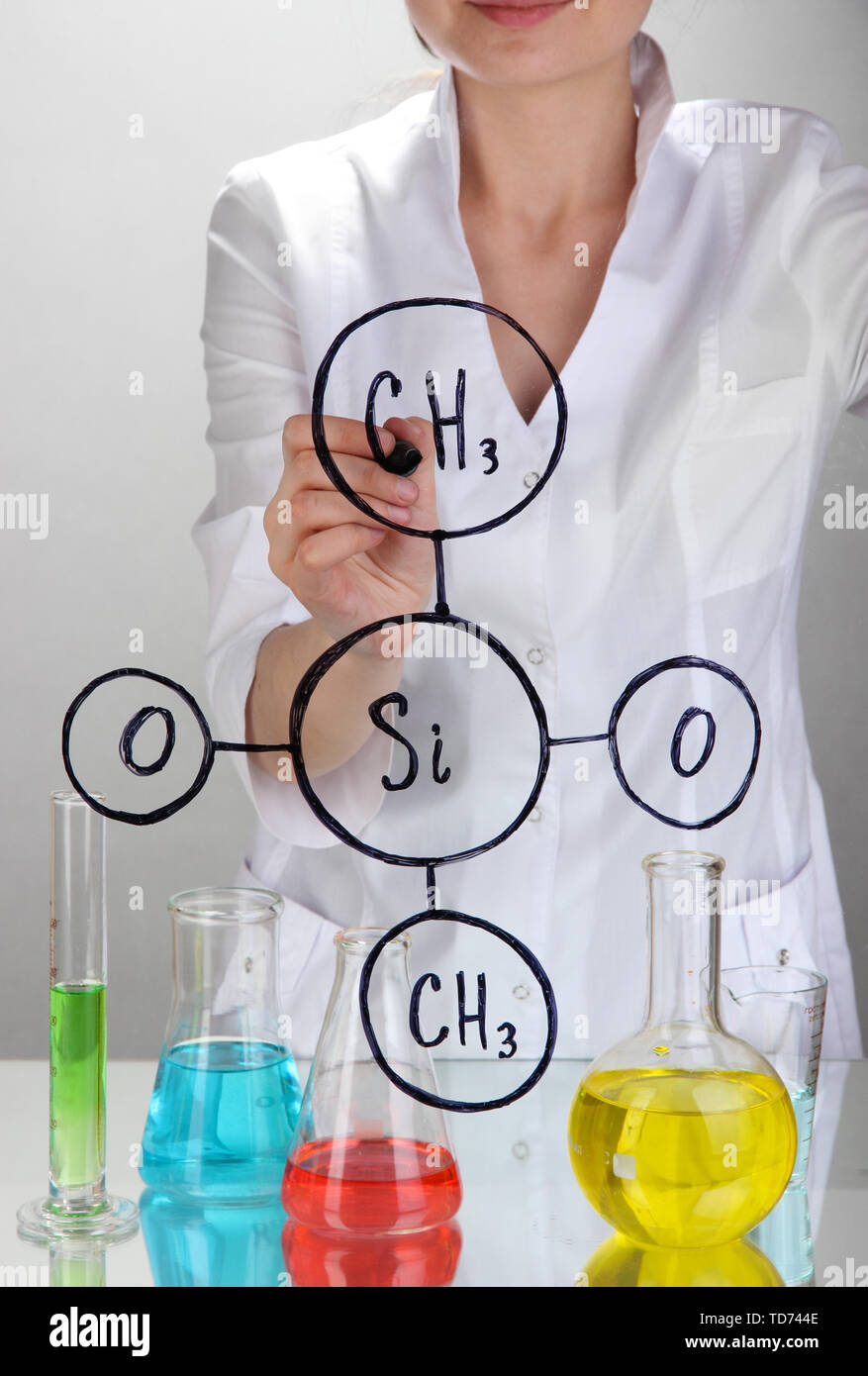 Chemist woman writing formulas on glass on grey background Stock Photo ...