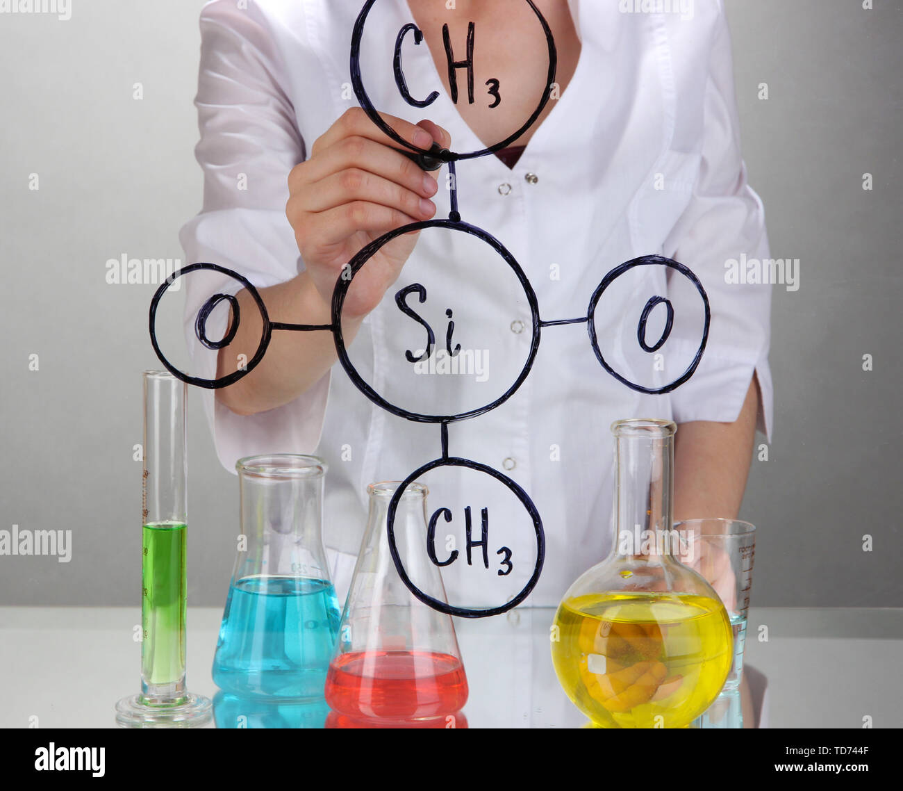 Chemist woman writing formulas on glass on grey background Stock Photo ...