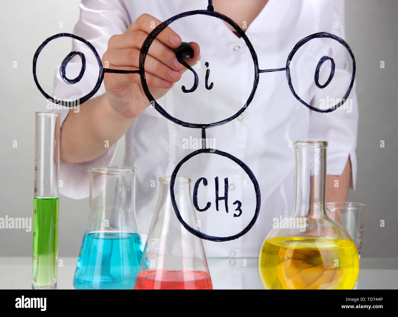 Chemist woman writing formulas on glass on grey background Stock Photo ...
