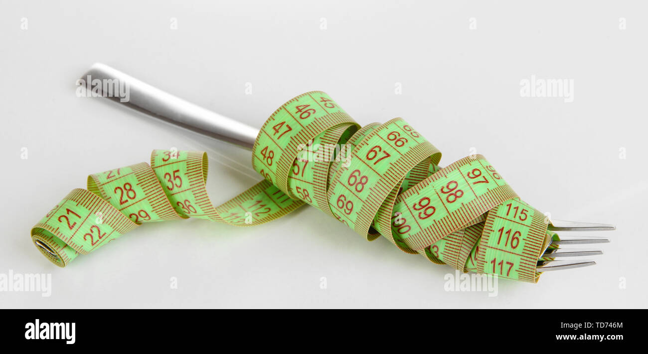 Fork tied measuring tape isolated on white Stock Photo - Alamy