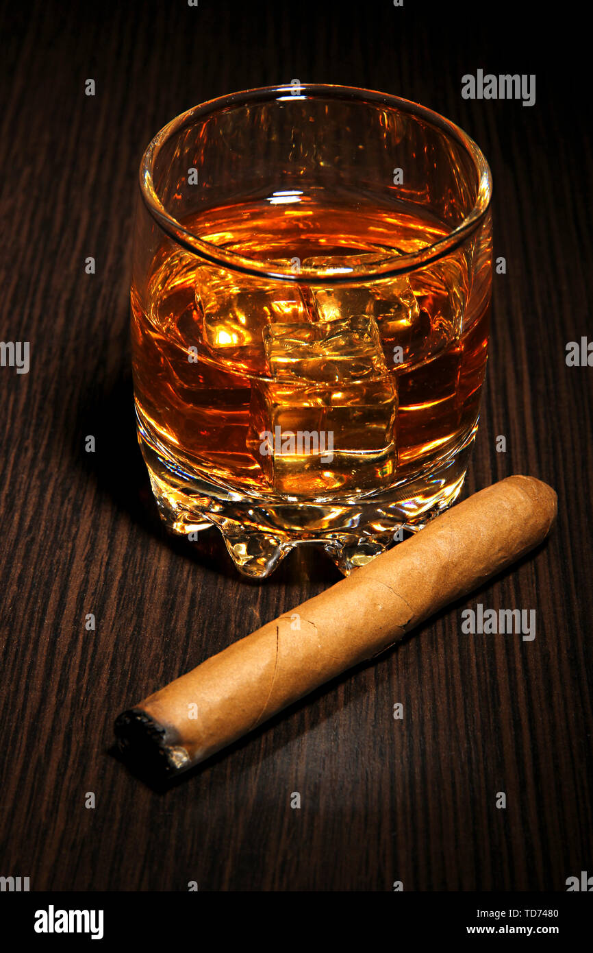 Brandy glass with ice on wooden background Stock Photo - Alamy