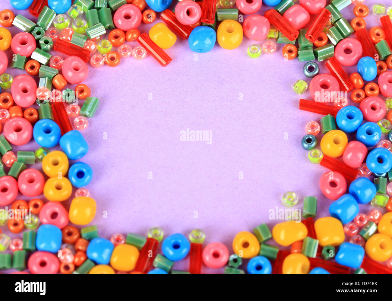 Different colorful beads on purple background Stock Photo - Alamy