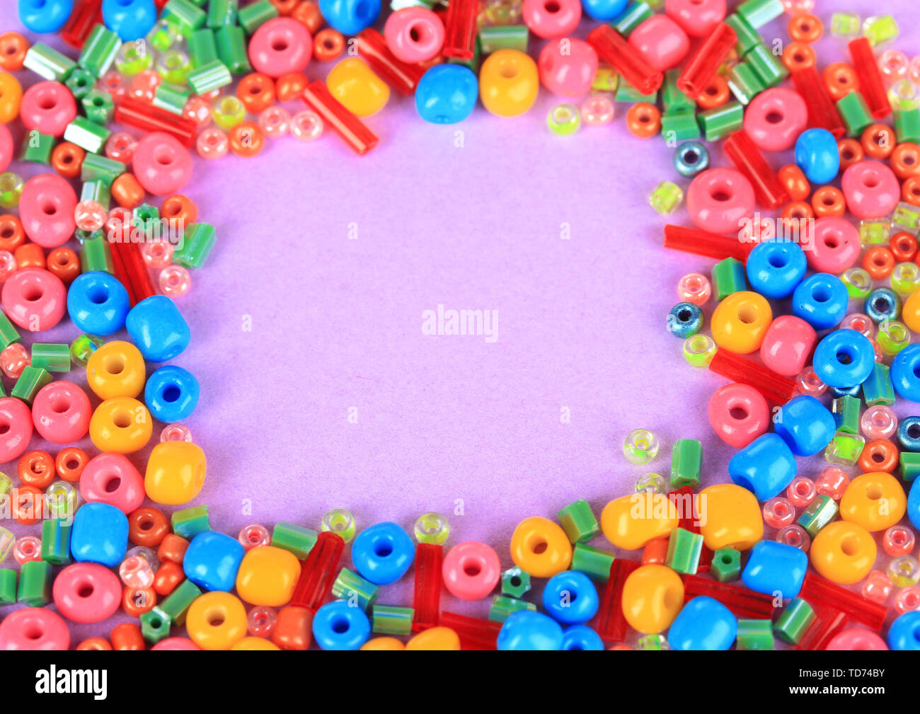 Different colorful beads on purple background Stock Photo - Alamy