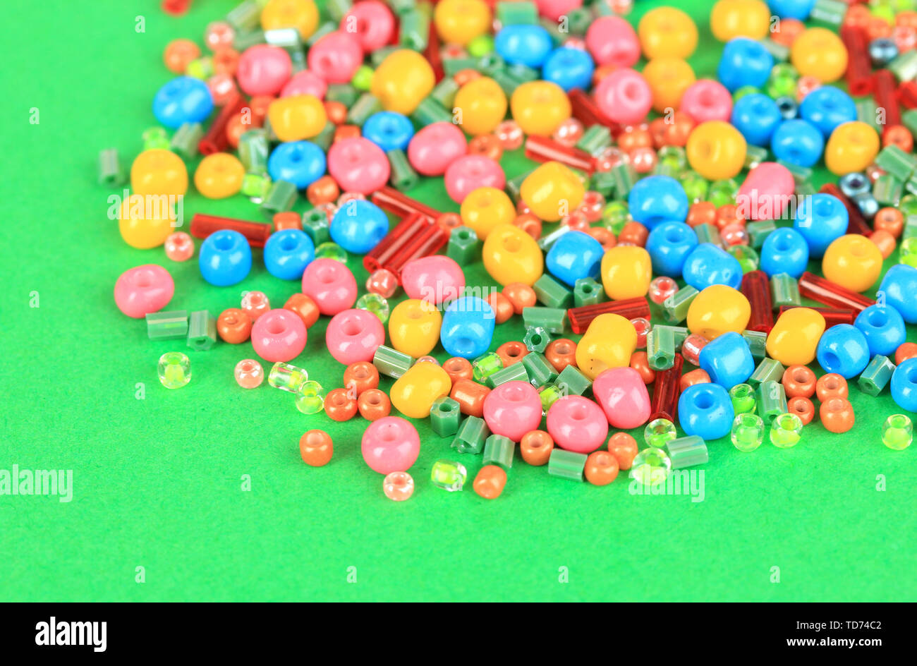 Different colorful beads on green background Stock Photo - Alamy