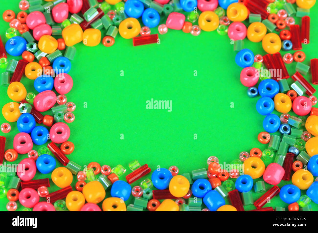 Different colorful beads on green background Stock Photo - Alamy