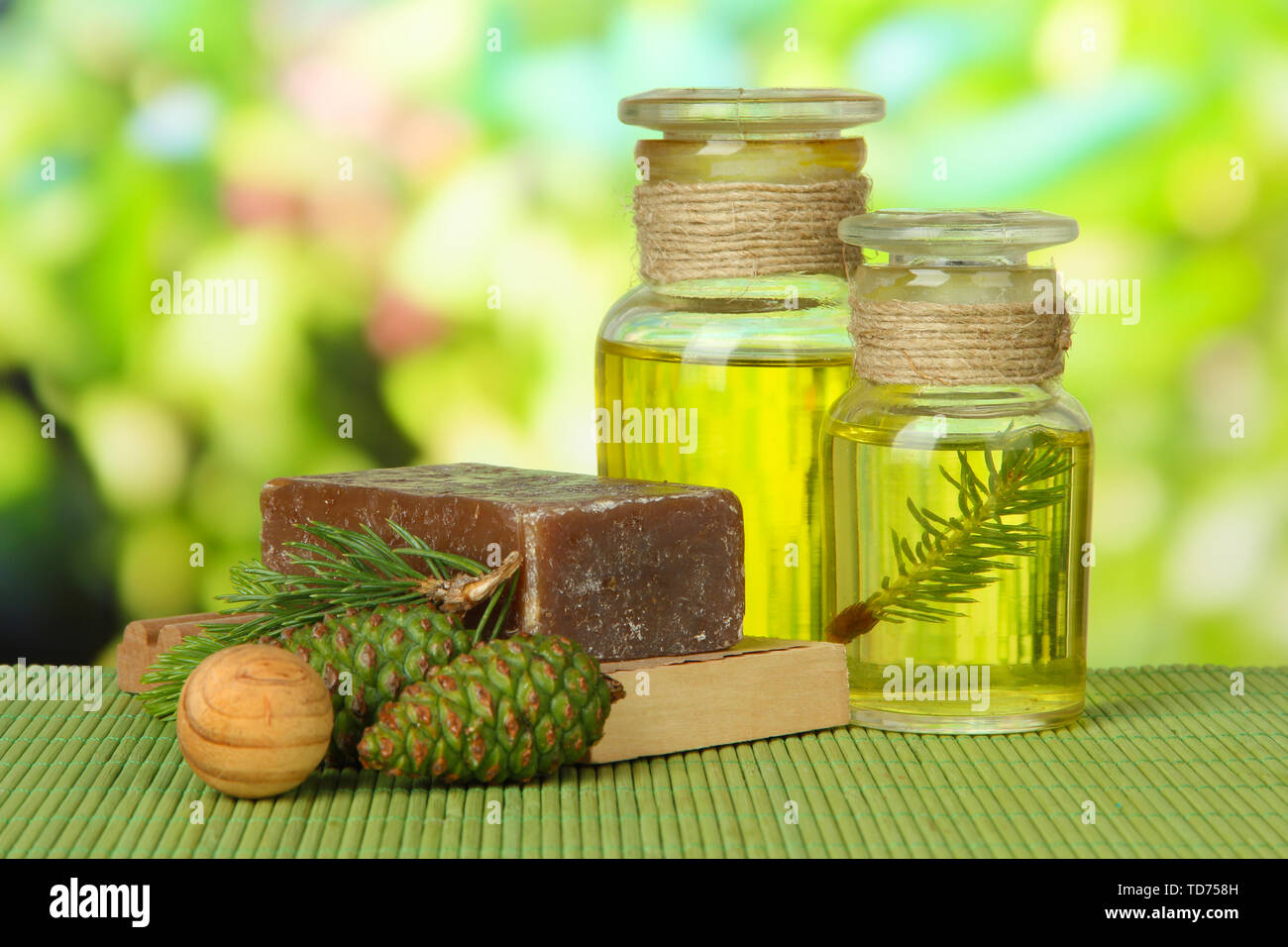 Hand-made soap and bottles of fir tree oil on bamboo mat Stock Photo ...