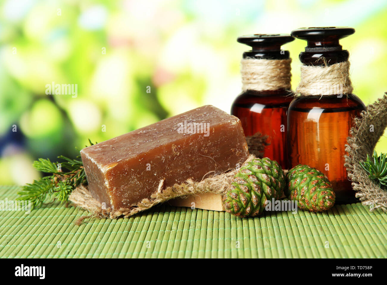 Hand-made soap and bottles of fir tree oil on bamboo mat Stock Photo ...