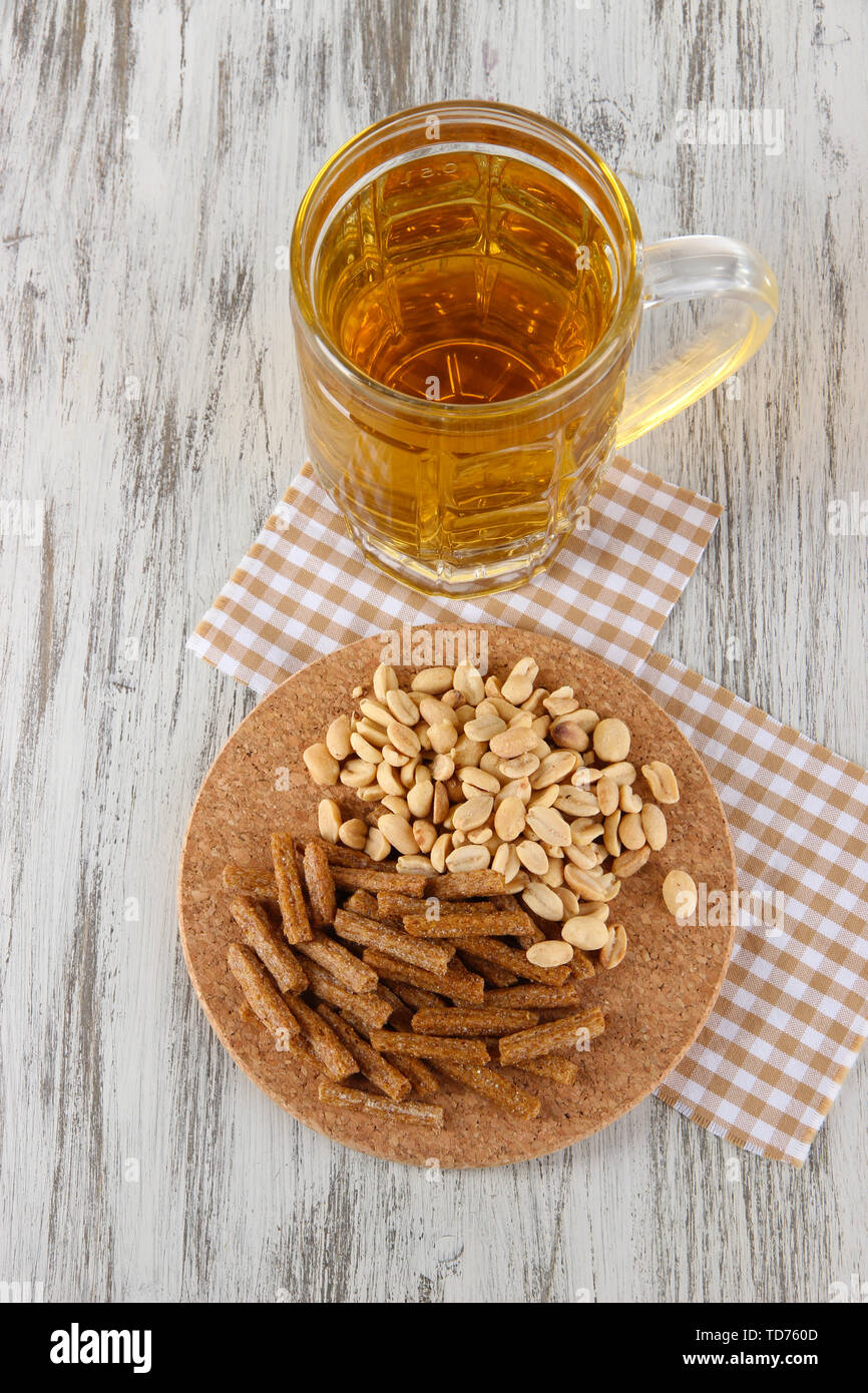 Beer in glass crunches, and nuts on napkin on wooden table Stock Photo ...