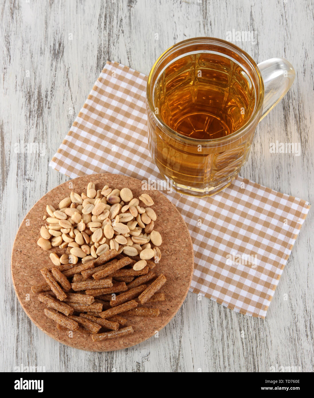 Beer in glass crunches, and nuts on napkin on wooden table Stock Photo ...