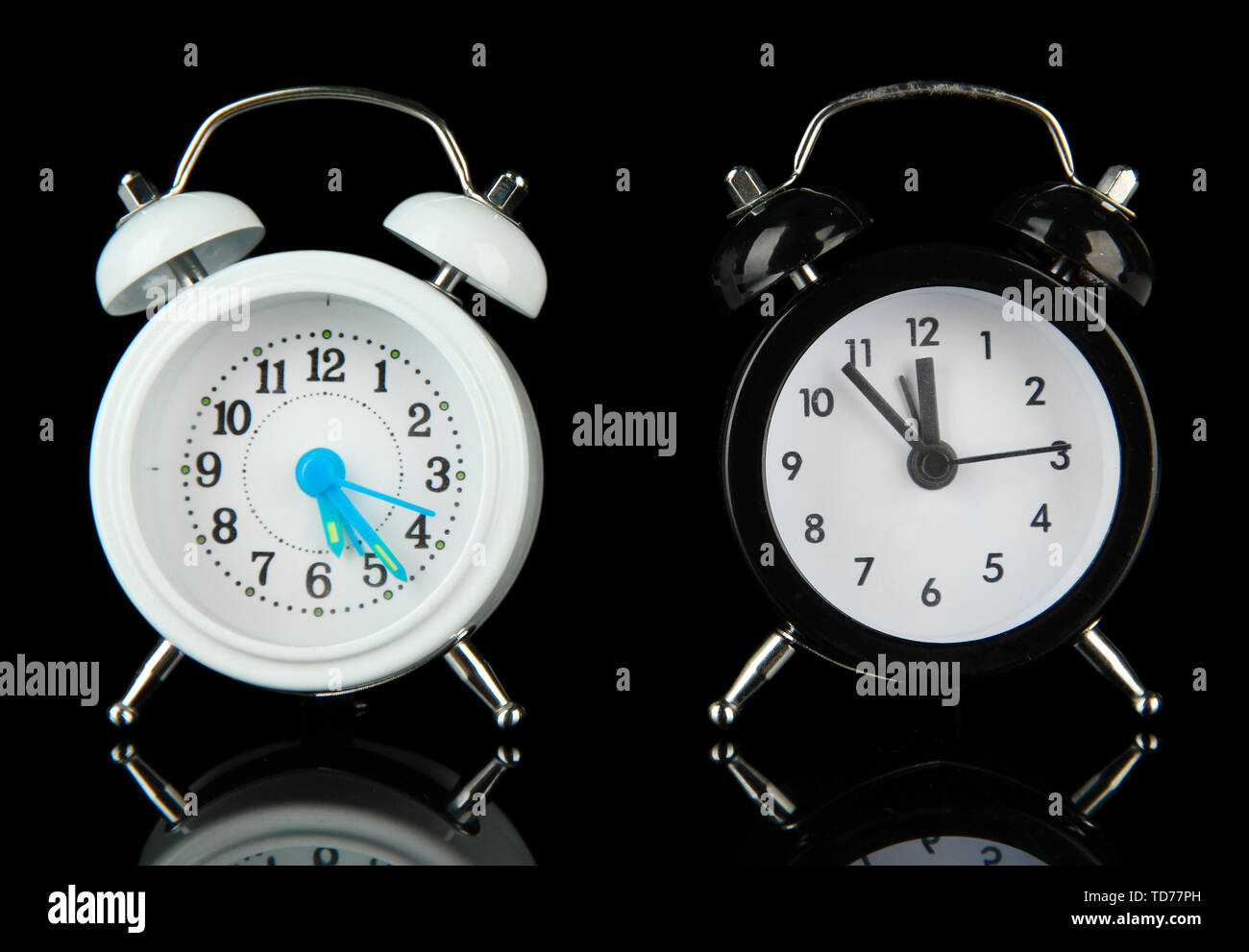 Two old style alarm clocks isolated on black Stock Photo - Alamy