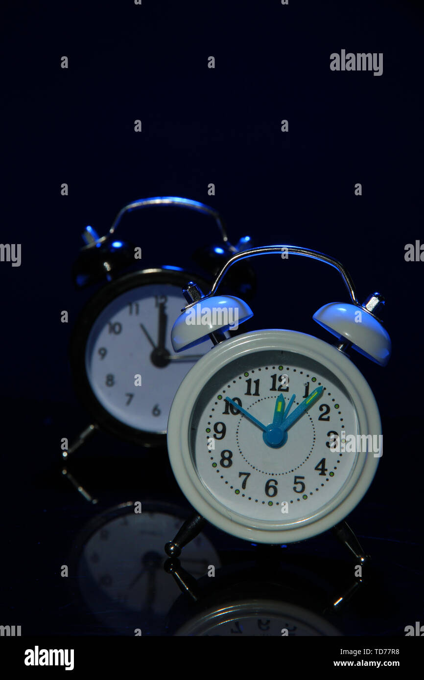 Two old style alarm clocks on dark color background Stock Photo - Alamy