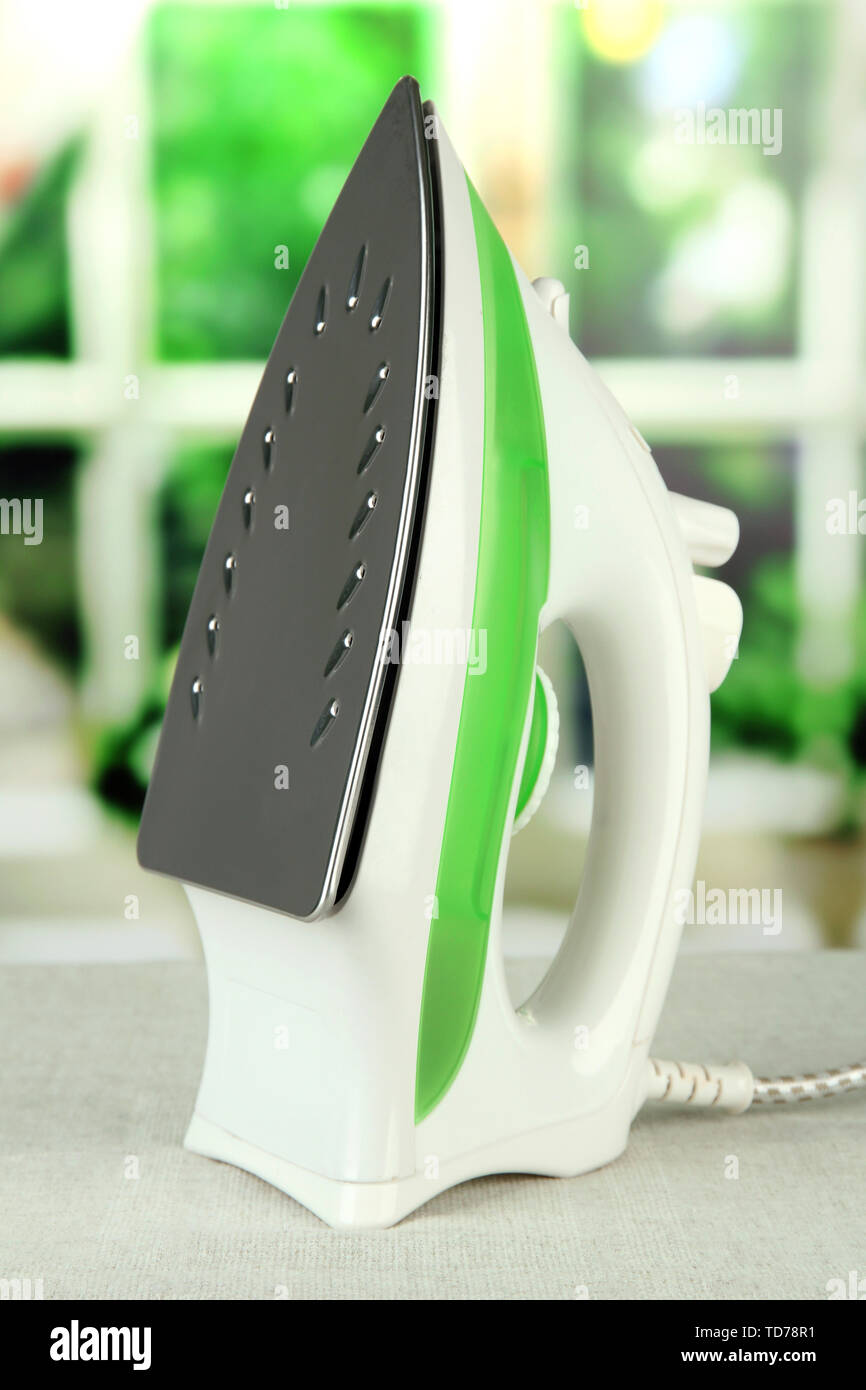 Steam iron on bright background Stock Photo - Alamy