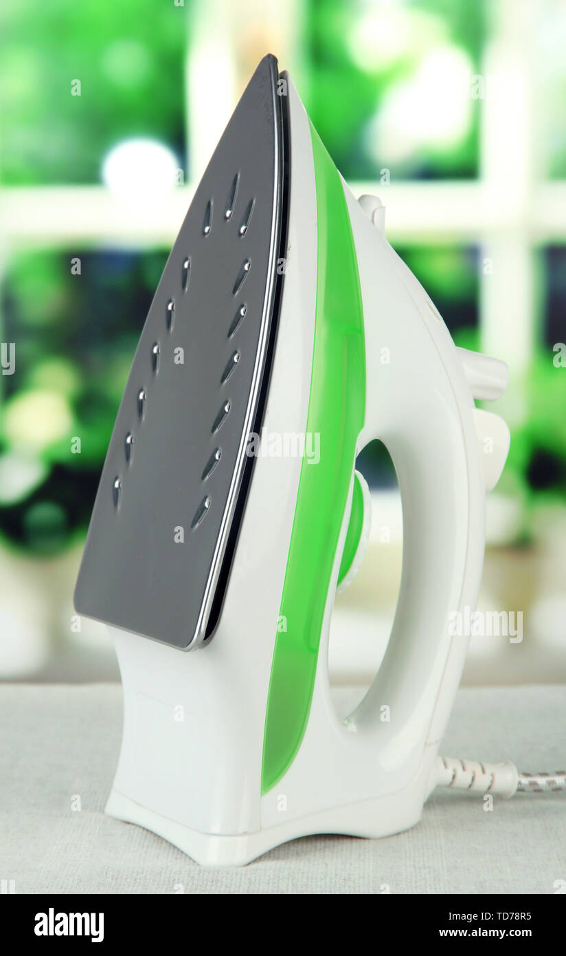 Steam iron on bright background Stock Photo - Alamy