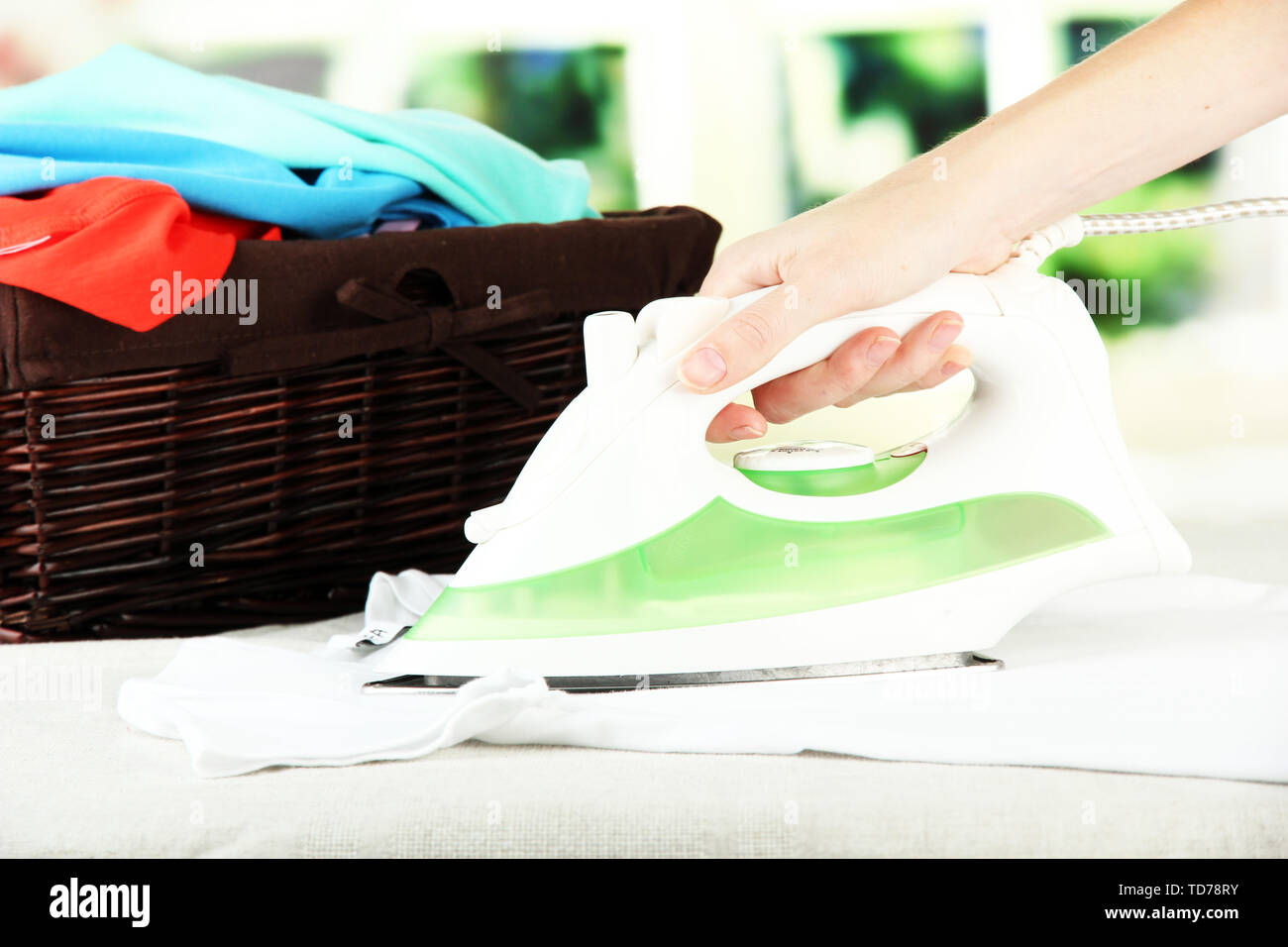 Woman's hand ironing clothes, on bright background Stock Photo - Alamy