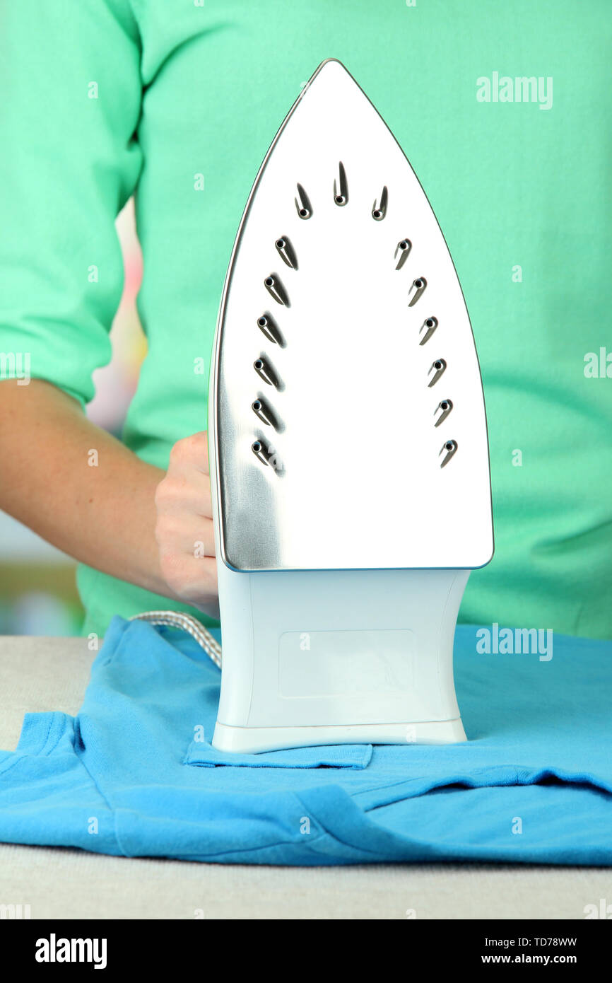 Woman's hand ironing clothes, on bright background Stock Photo - Alamy