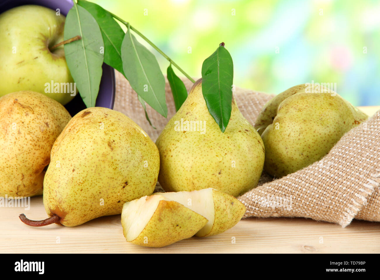 Pears in bucket on burlap on wooden table on nature background Stock ...