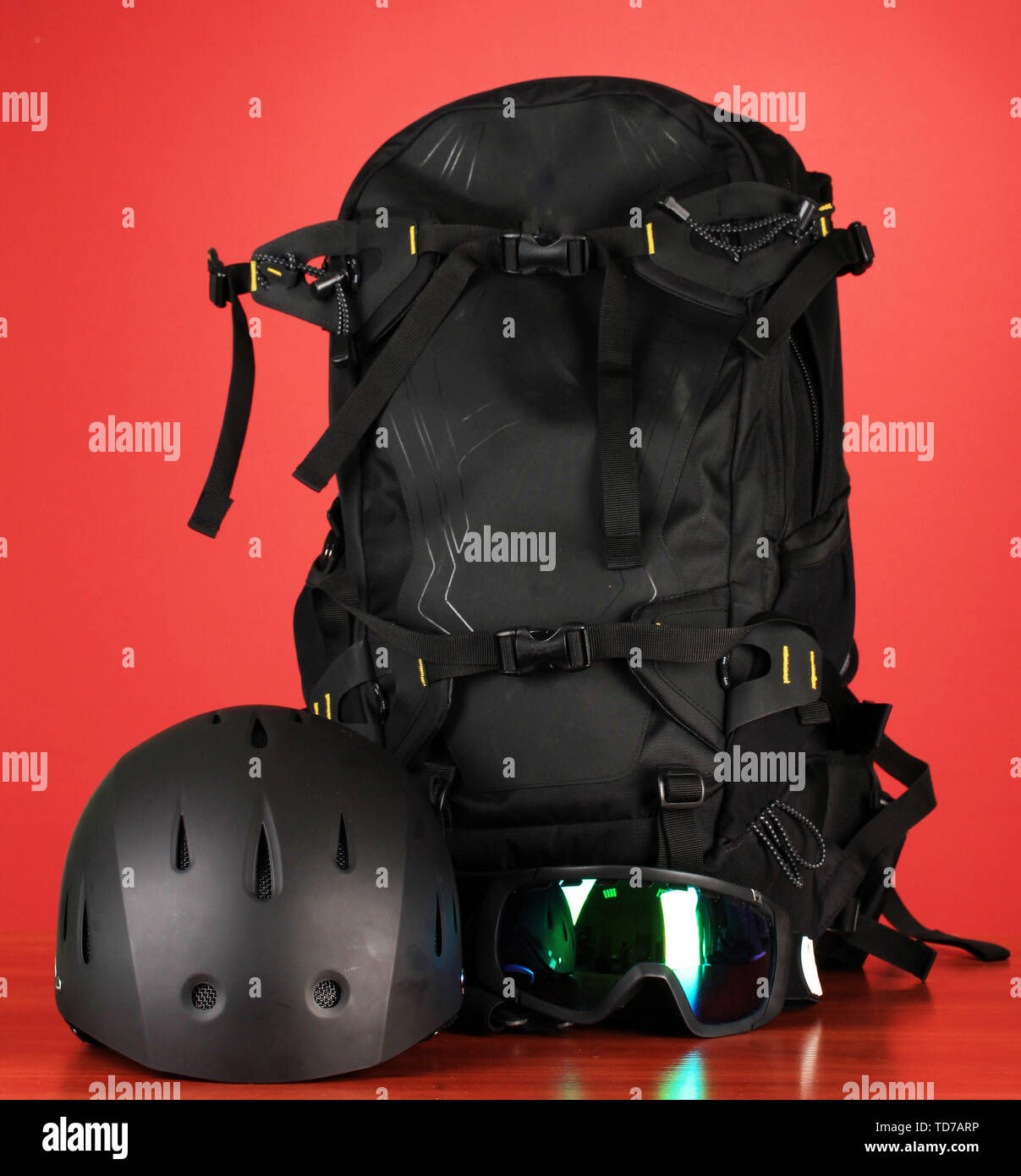 Winter sport glasses, helmet and gloves, backpack, on red background ...