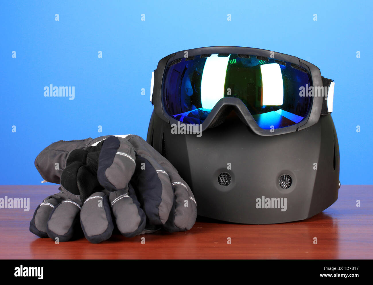 Winter sport glasses, helmet and gloves, on blue background Stock Photo ...