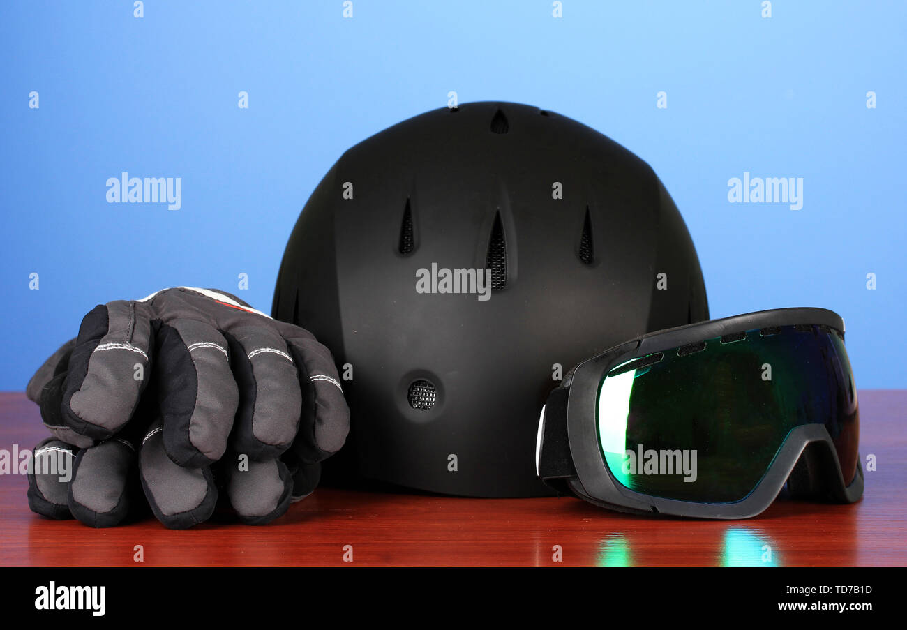 Winter sport glasses, helmet and gloves, on blue background Stock Photo ...