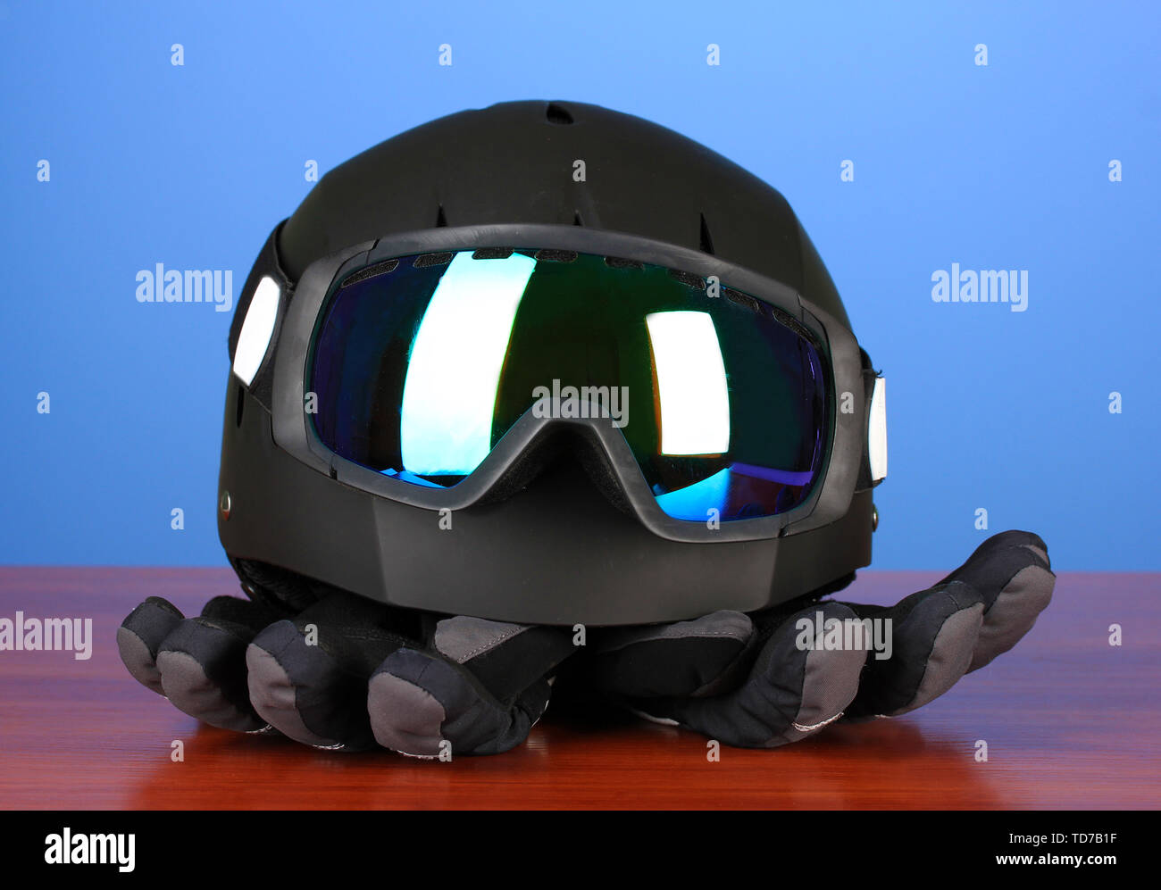 Winter sport glasses, helmet and gloves, on blue background Stock Photo ...