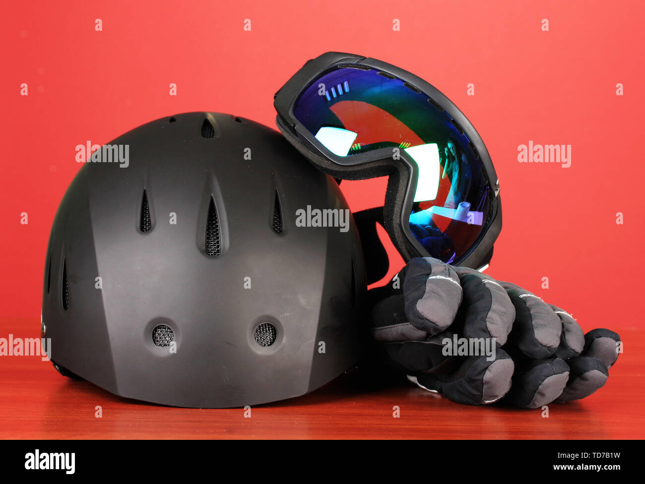 Winter sport glasses, helmet and gloves, on red background Stock Photo ...