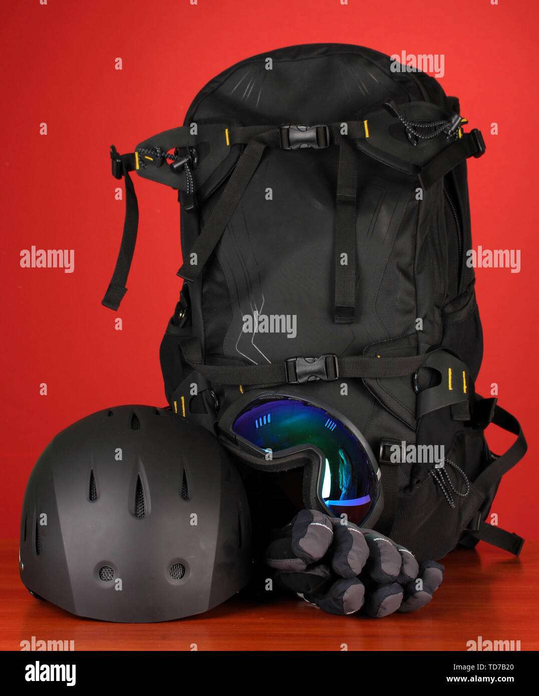 Winter sport glasses, helmet and gloves, backpack, on red background ...