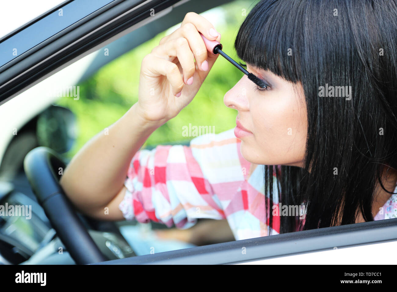 Young woman applying makeup in car Stock Photo - Alamy
