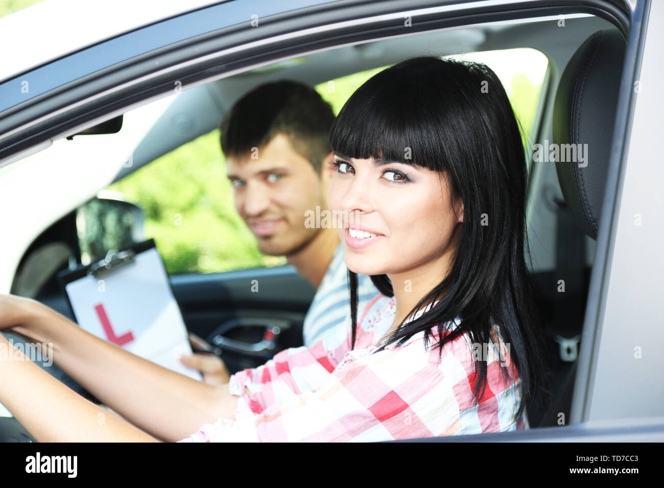Beautiful young woman taking driving lesson Stock Photo - Alamy