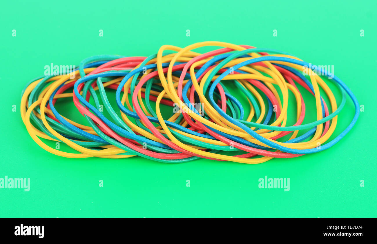 Colorful rubber bands on green background Stock Photo - Alamy