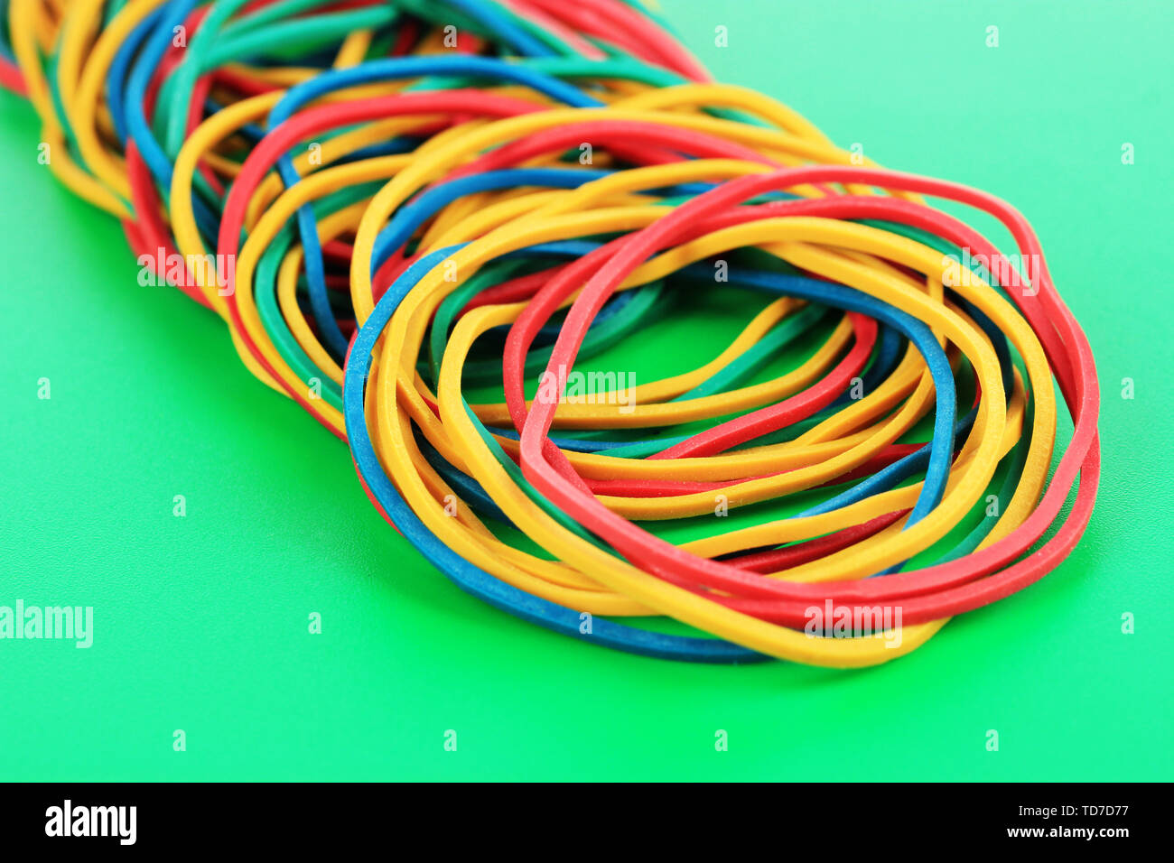 Colorful rubber bands on green background Stock Photo - Alamy