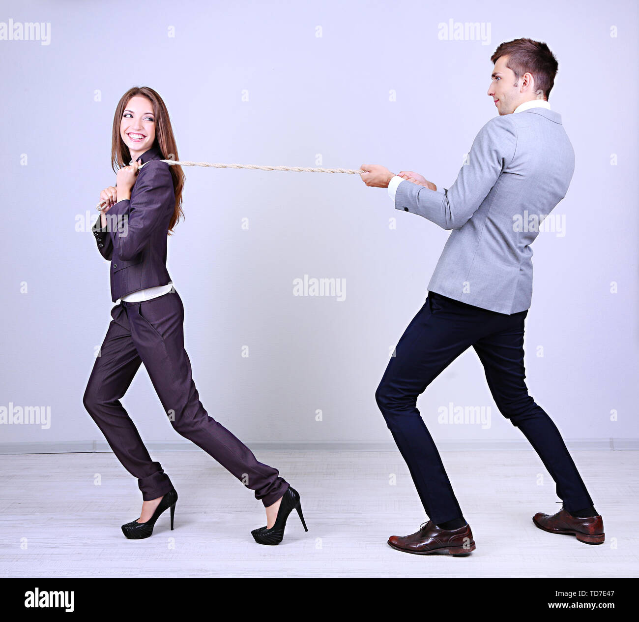 Business people stretching rope Stock Photo - Alamy