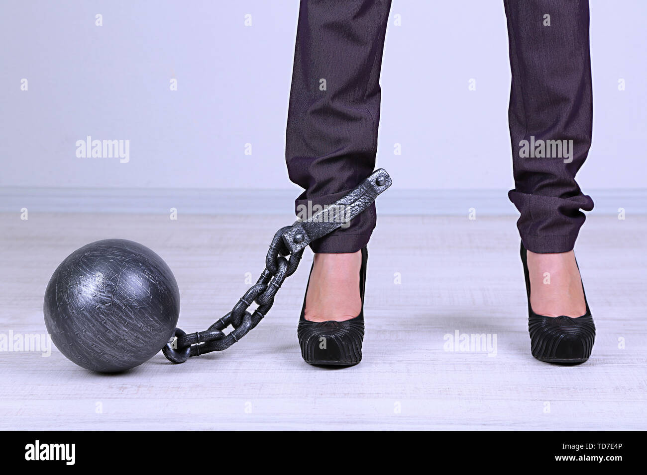 Business worker with ball and chain attached to foot Stock Photo - Alamy