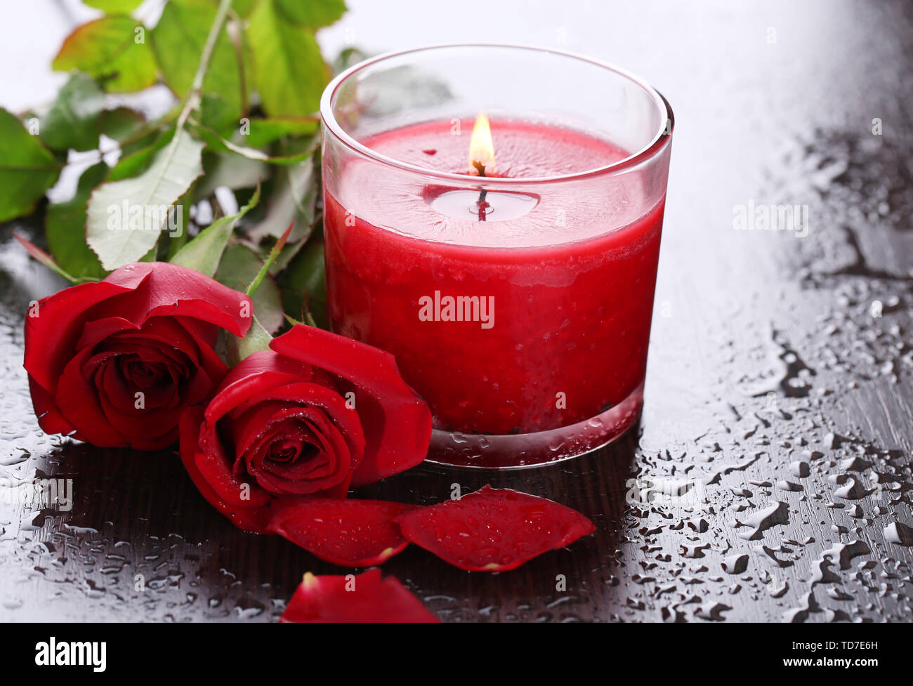 Beautiful romantic red candle with flowers, close up Stock Photo - Alamy