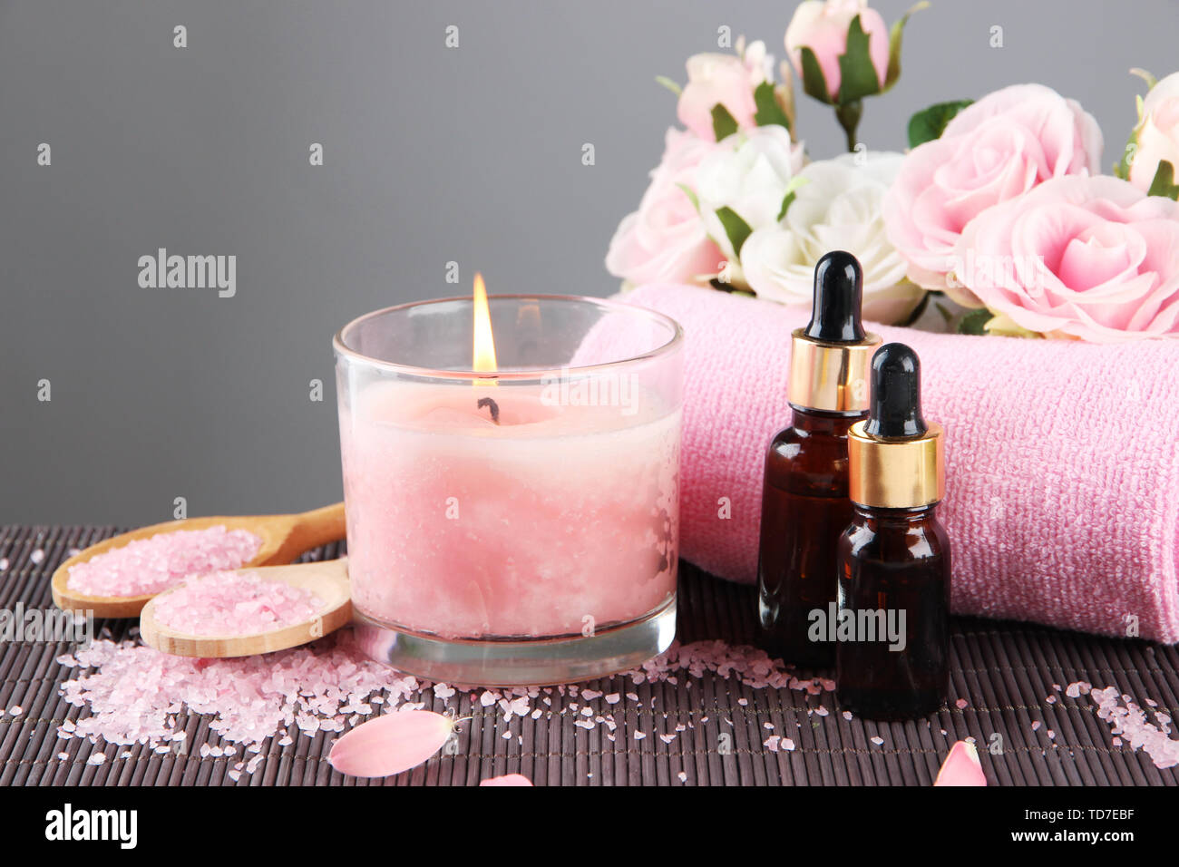 Beautiful pink candle with flowers and towel on bamboo mat Stock Photo ...