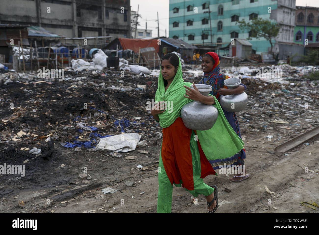 Dhaka, Bangladesh. 13th June, 2019. Boys and girls collect pure drink ...
