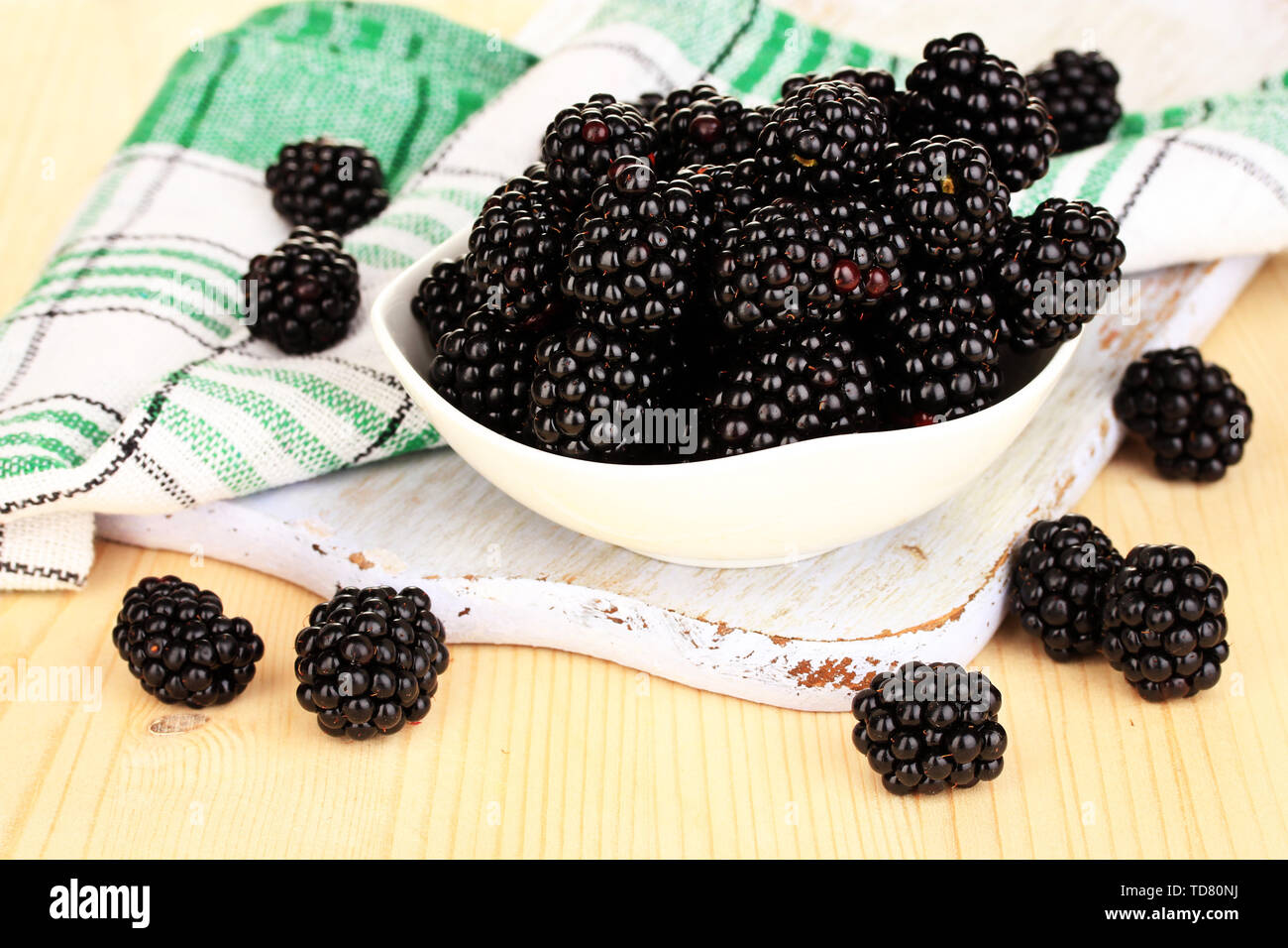 Sweet blackberry in bowl on wooden table Stock Photo - Alamy