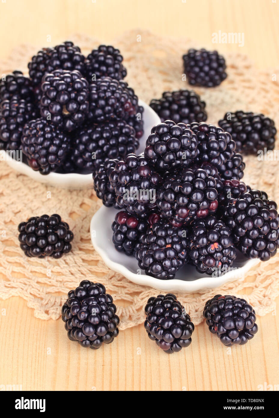 Sweet blackberry in bowls on wooden table Stock Photo - Alamy