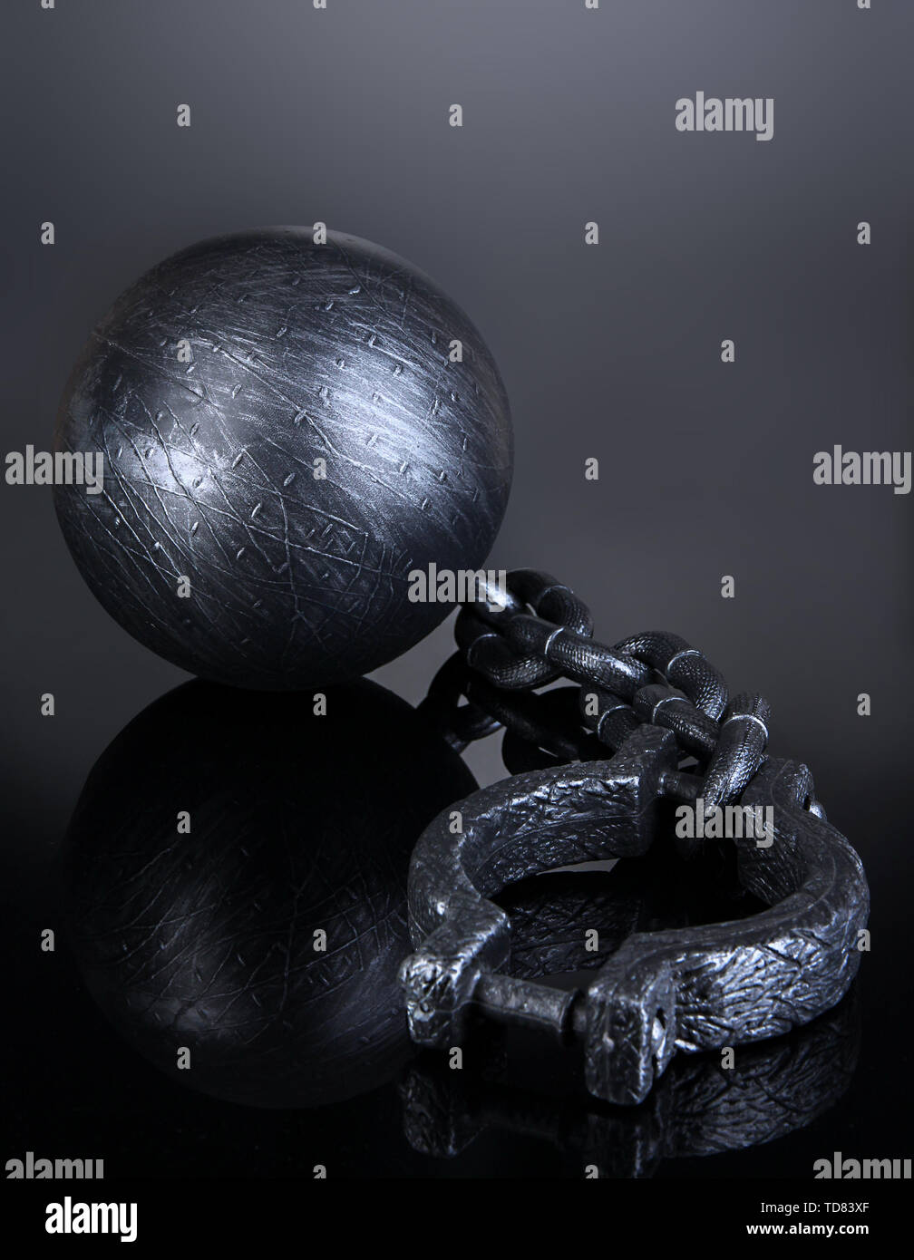 Ball and chain on grey background Stock Photo - Alamy