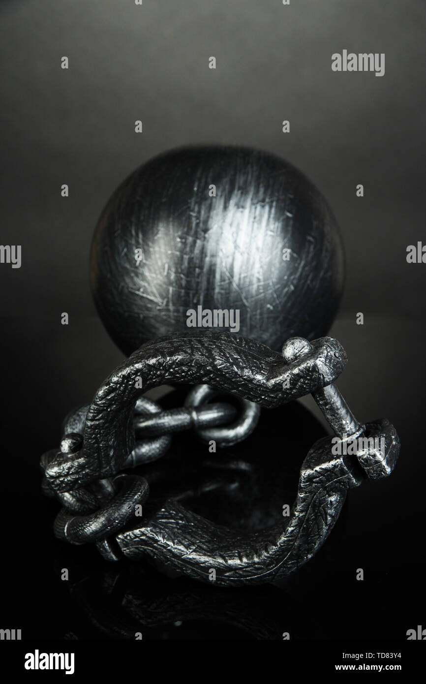 Ball and chain on grey background Stock Photo - Alamy