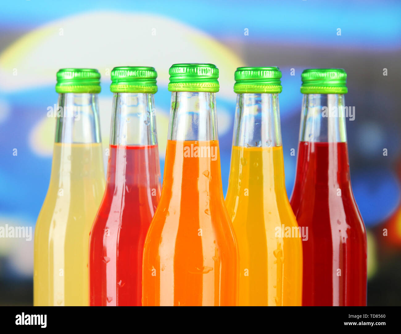 Bottles with tasty drinks on bright background Stock Photo - Alamy