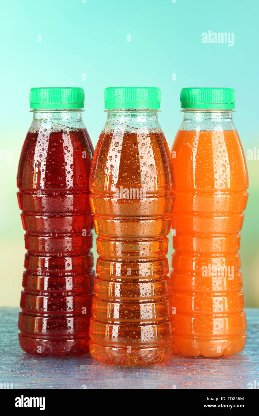 Assortment of bottles with tasty fruit juices on bright background ...