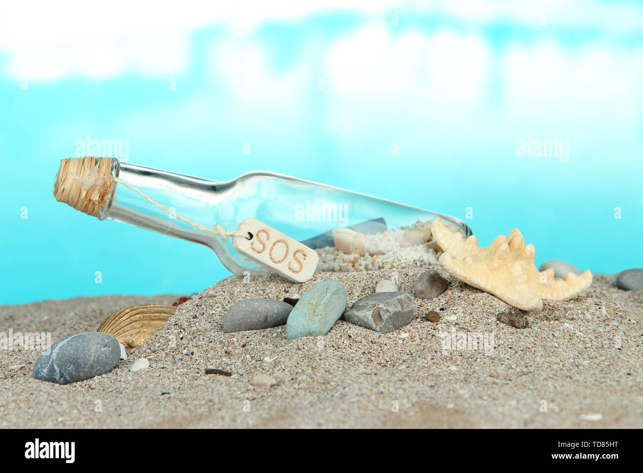 Glass of bottle with note inside on bright blue background Stock Photo ...