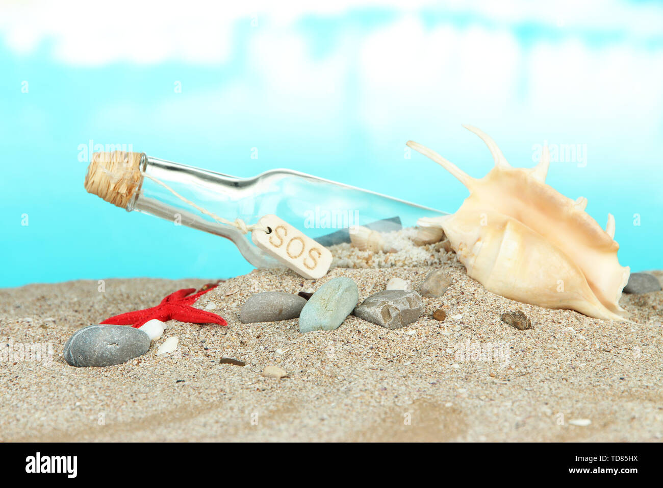 Glass of bottle with note inside on bright blue background Stock Photo ...
