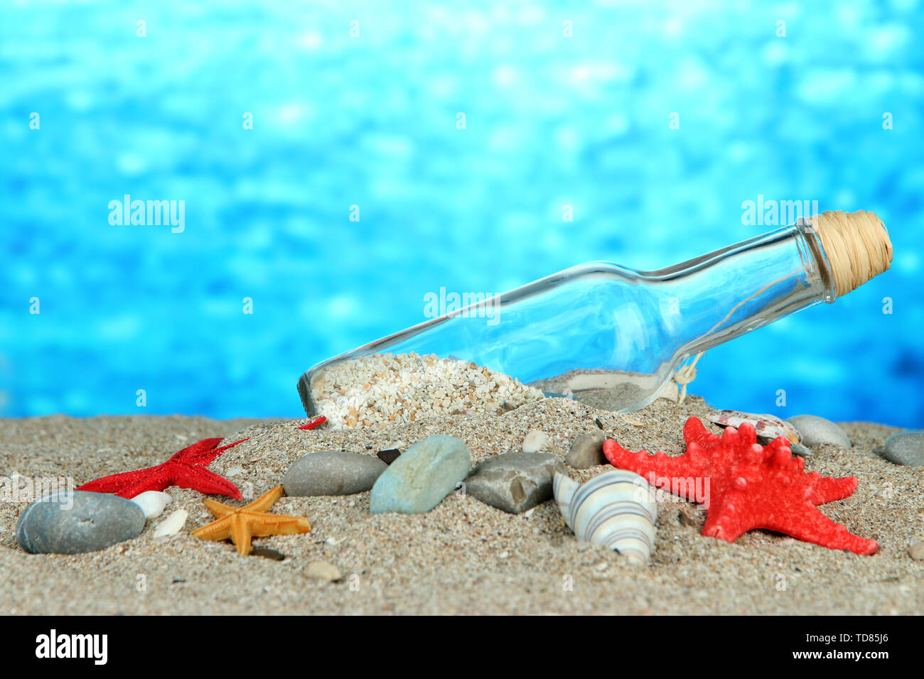 Glass of bottle with note inside on bright blue background Stock Photo ...