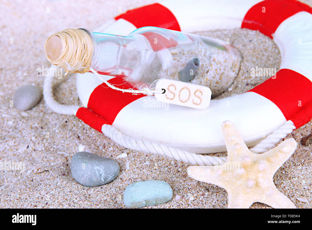 Glass of bottle with note inside on sand background Stock Photo - Alamy
