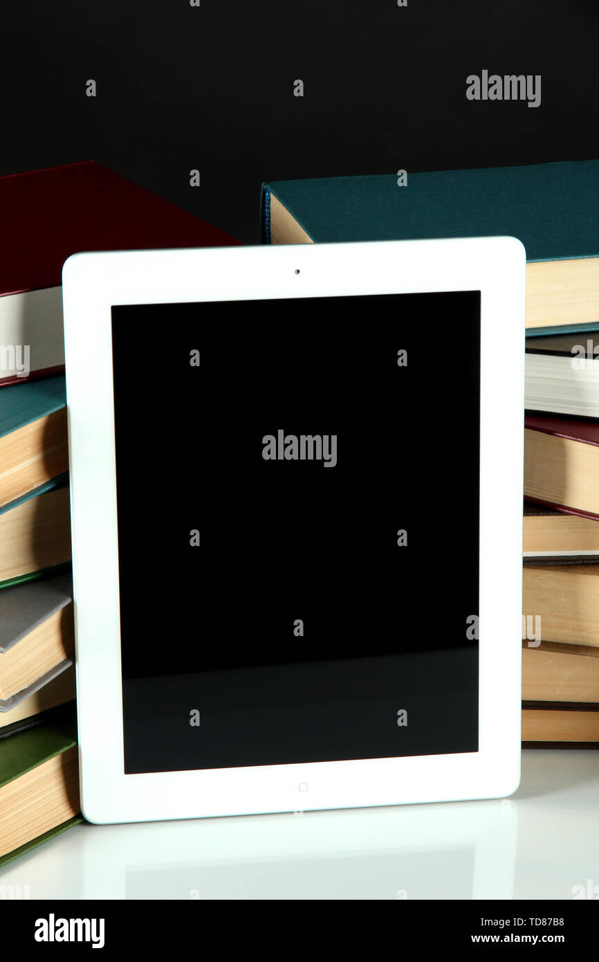 Tablet and books on bright background Stock Photo - Alamy