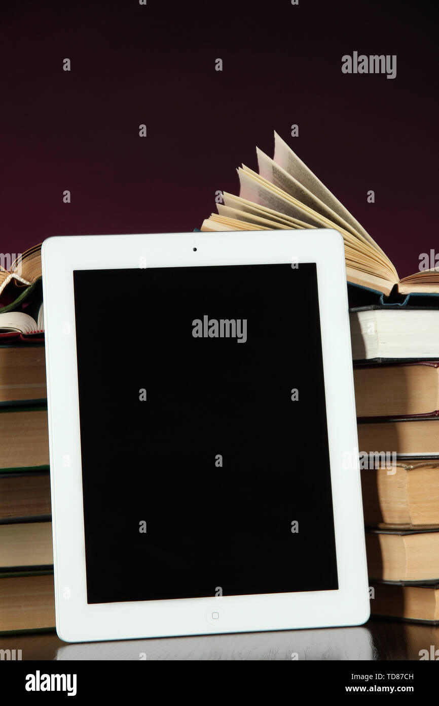 Tablet and books on bright background Stock Photo - Alamy